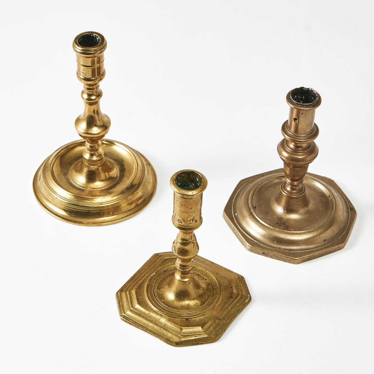 A set of three 18th century candlesticks, late baroque, turned and cast ...