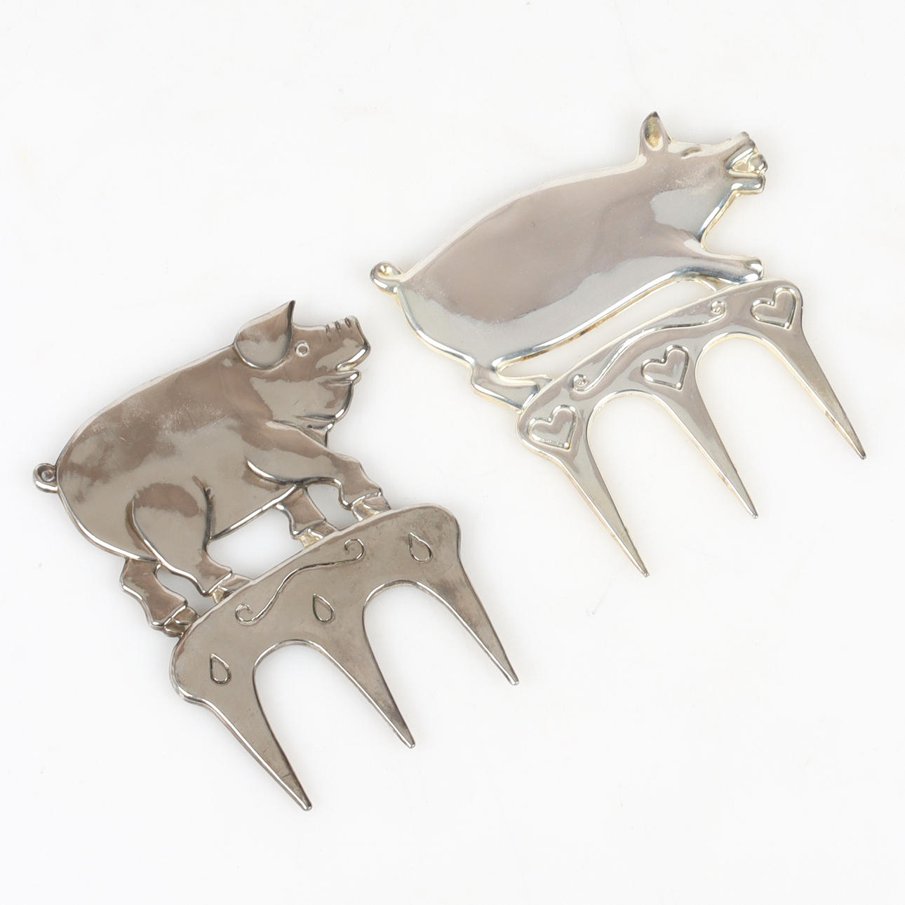 A pair of ham forks, in the shape of pigs, 20th century. Silver ...