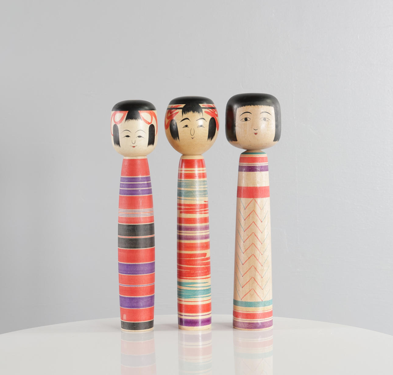 Ein Set aus drei japanischen Kokeshi-Puppen im Vintage-Stil, handbemalt ...