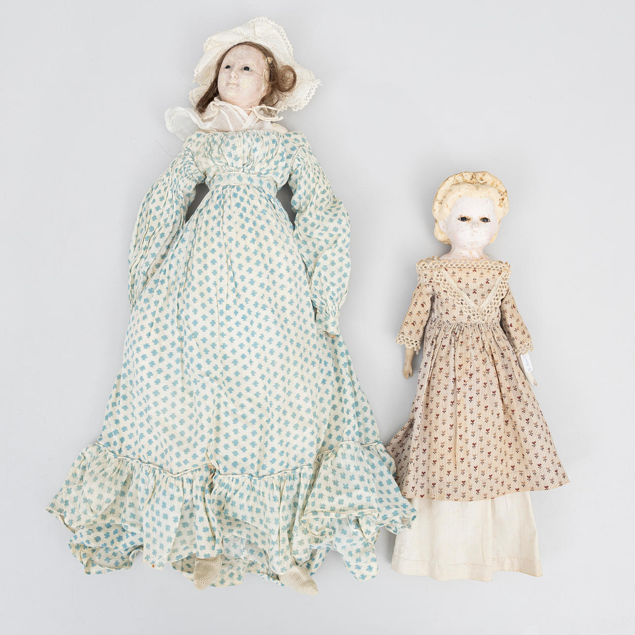 A pair of textile composite dolls, a head of waxed papier-mâché, 19th ...