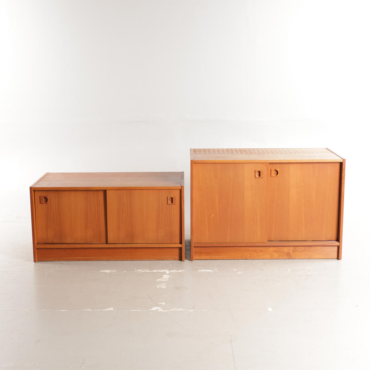 DANSK MØBELDESIGN. Two low cabinets of teak, front with sliding doors ...
