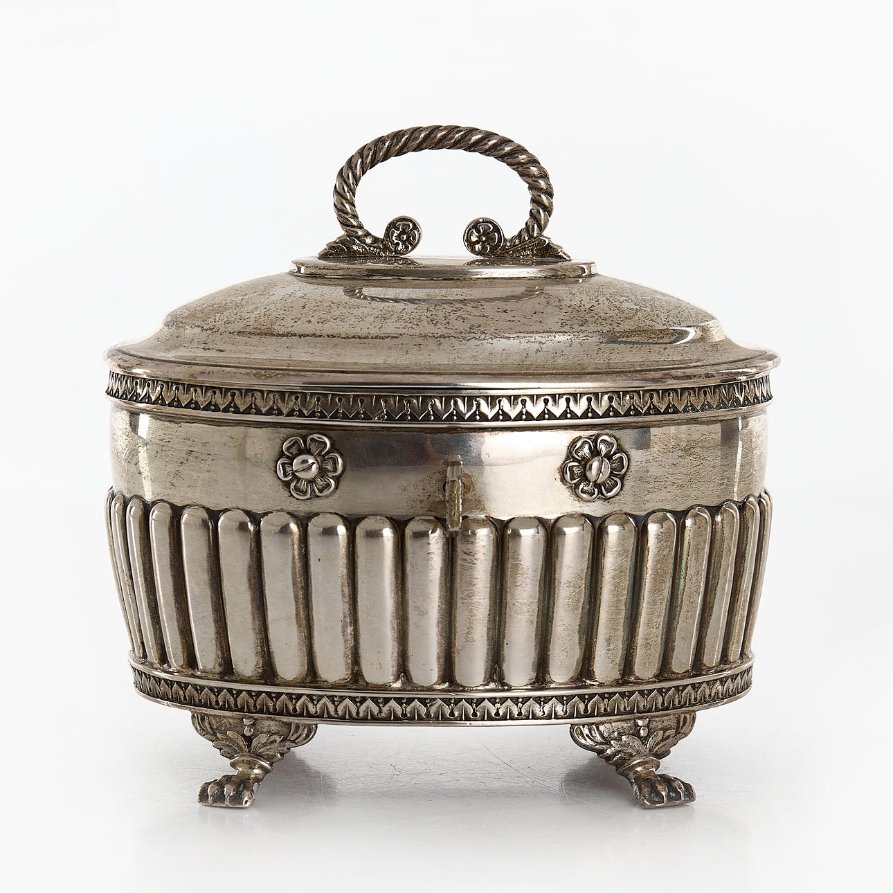 A silver sugar box, gilt inside, oval shape on four feet in the shape ...