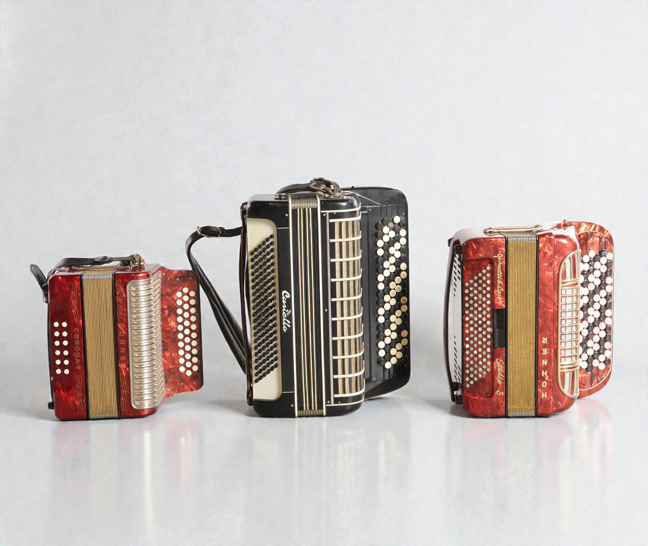 Button accordions, red and black cabinets, Castello and Hohner (3 ...