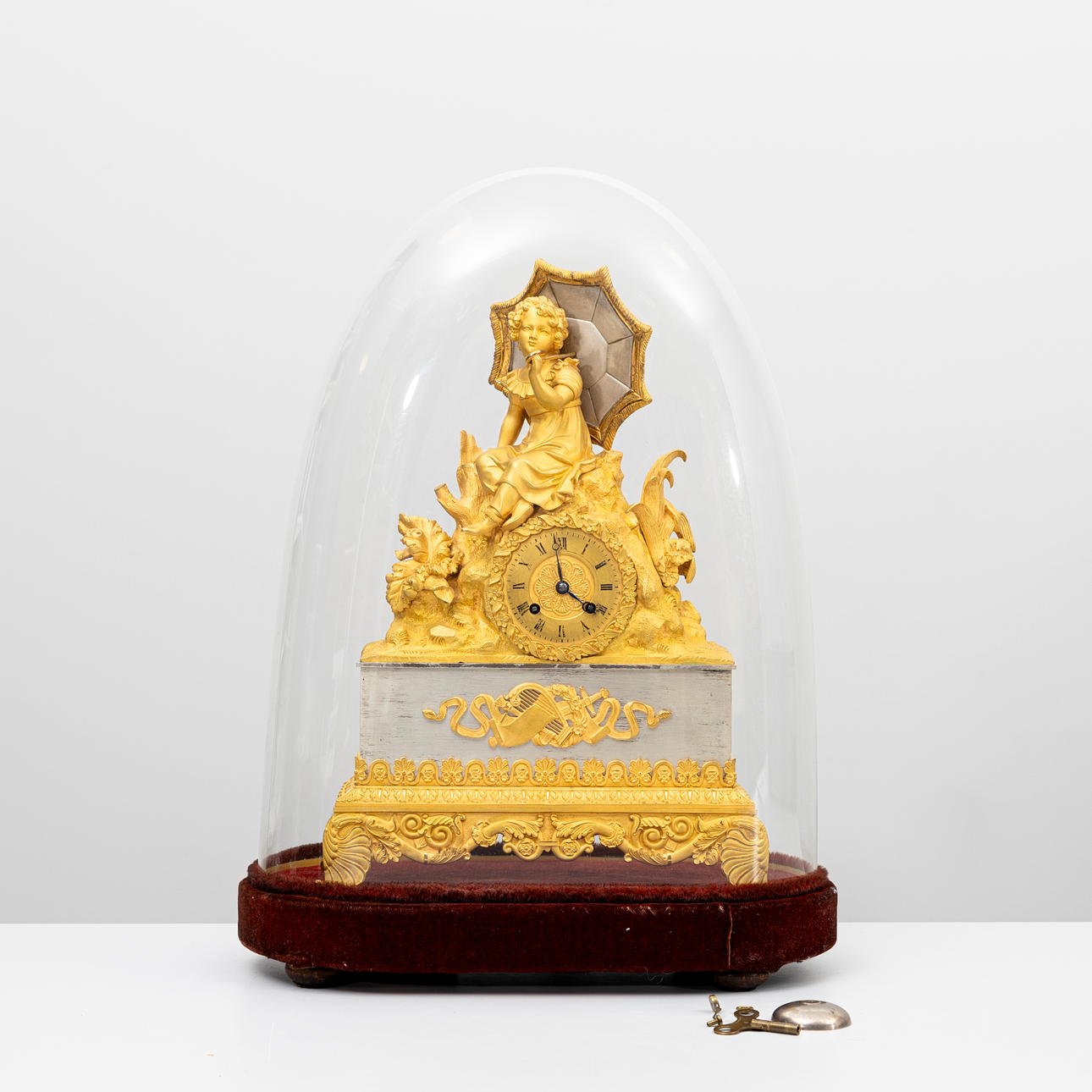 MANTEL CLOCK, gilt and silvered bronze, velvet-covered wooden base ...