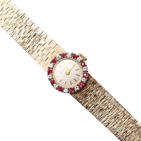 A LADY'S GOLD, RUBY AND DIAMOND WRISTWATCH BY BUECHE GIROD. Clocks ...