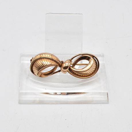 ANDREAS DAUB. GILT DESIGNER BROOCH IN A LOOP-FORM, AROUND 1950, WITH ...