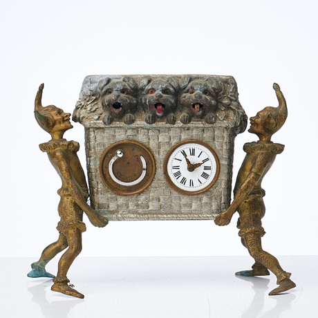 TABLE CLOCK. The clock carried by two narnars in patinated brass, three ...