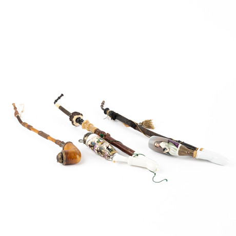 A set of three long pipes and a pipe head made of porcelain with a ...