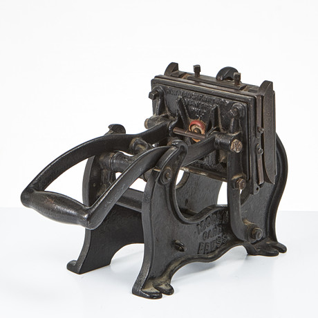 A cast iron card press, circa 1900, marked “Model Card Press ...