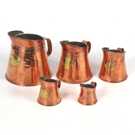 A set of five copper measuring cups, early 20th century. Silver ...