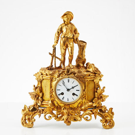 A Neo-Rococo table clock with a young man holding an axe, gilt metal ...