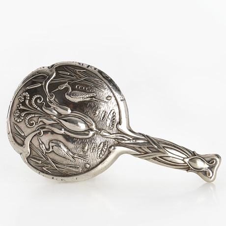 A silver hand mirror by William Aitken, Birmingham 1905, decorated with ...