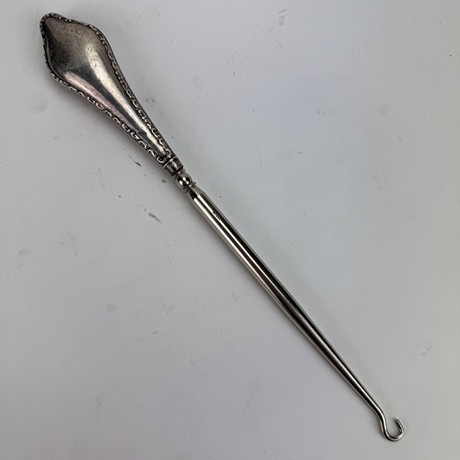 A silver and white metal string puller, England, 20th century. Silver ...