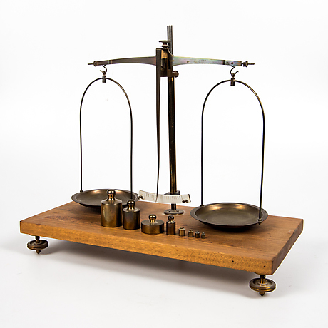 BALANCING SCALE WITH WEIGHTS, brass on a wooden stand, early 20th ...