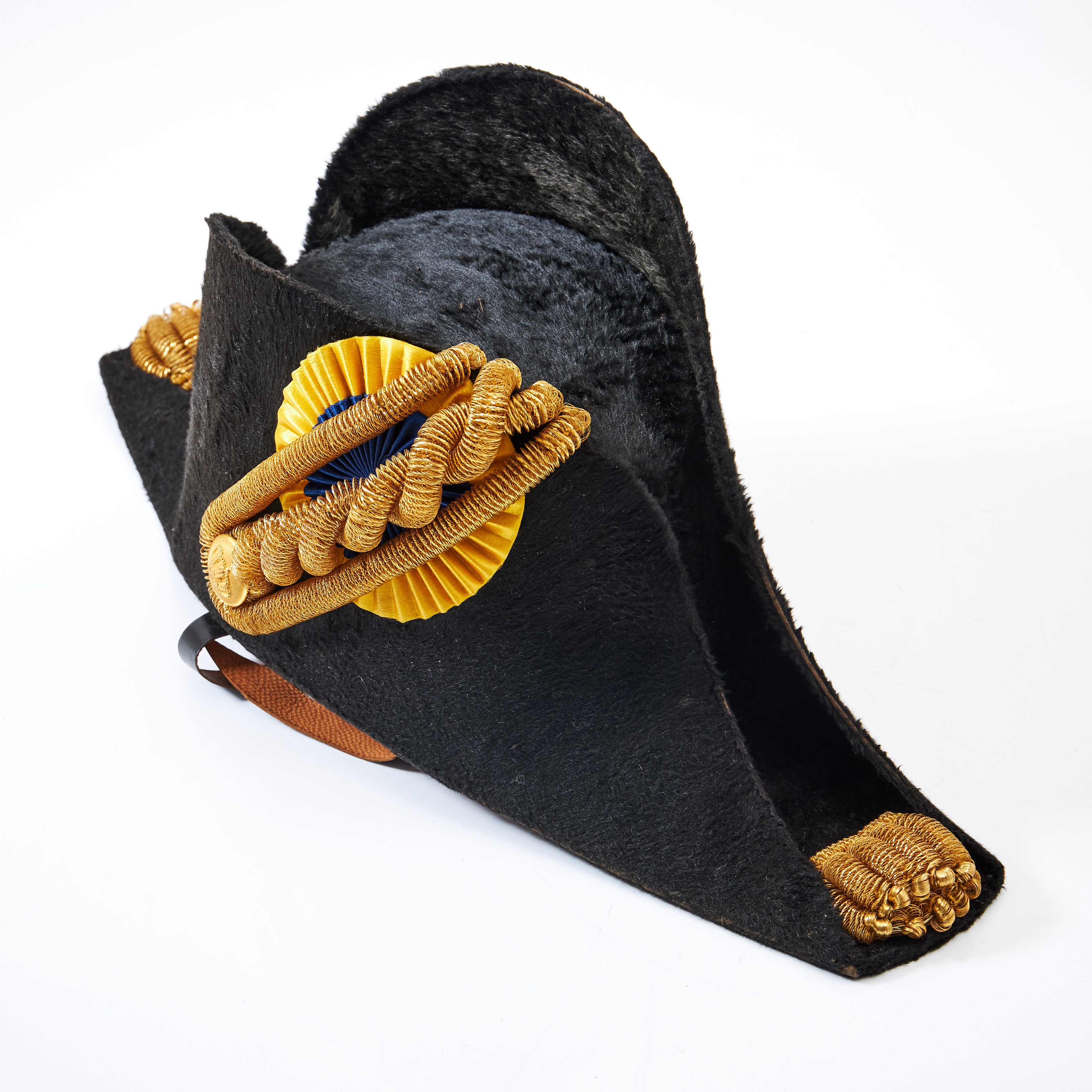 BICORNE of black silk felt edged with wide gold halo. Weapons ...